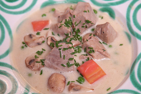 Kalbsragout in weißer Sauce mit Gemüse, mit Baguette serviert von ...