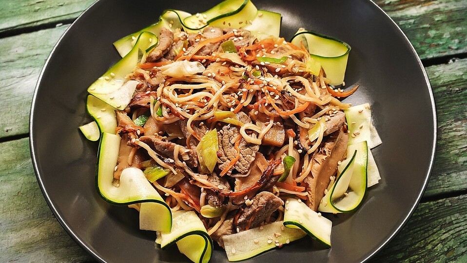 Gebratene Mie-Nudeln mit Rindfleisch, Shiitake-Pilzen und roh marinierten Zucchini-Streifen von ...