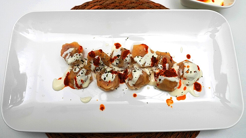 Hausgemachte Pelmeni, gefüllt mit würzigem Fleisch, serviert mit einer ...